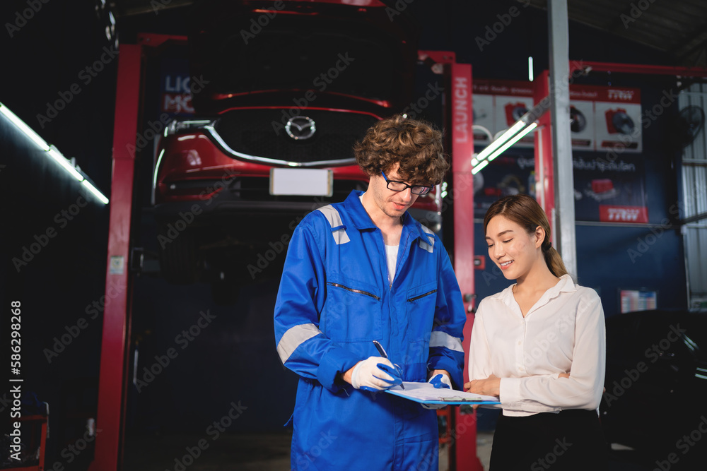 Caucasian male mechanic shows car repair report to Middle Eastern ...