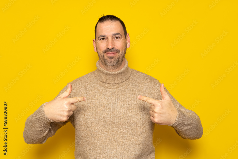 The portrait of a bearded handsome man points to himself puzzled at ...