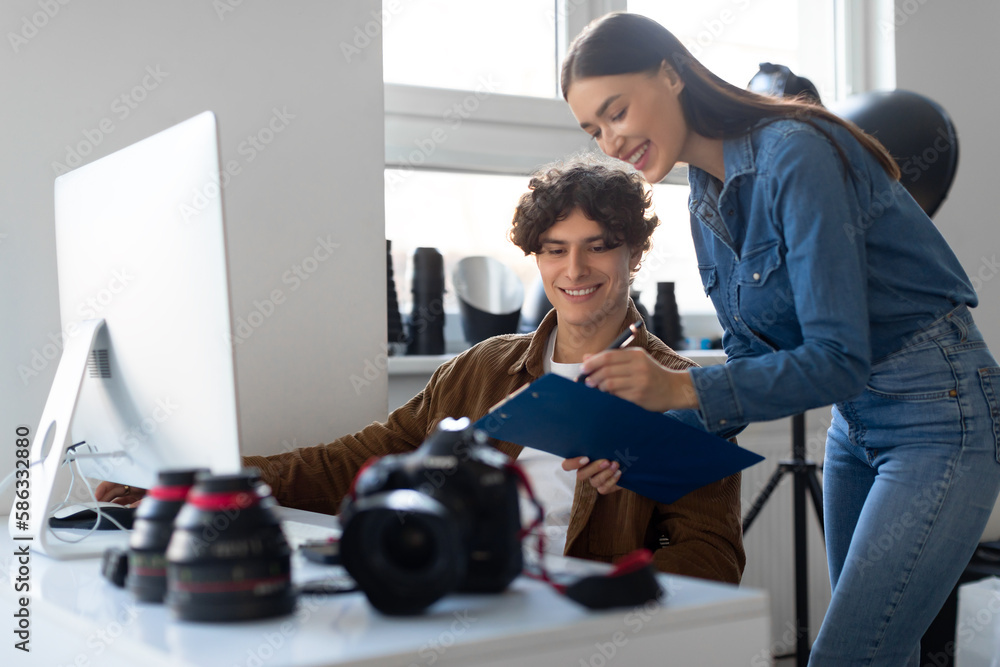 Foto de Female photo assistant with checklist and male photographer ...