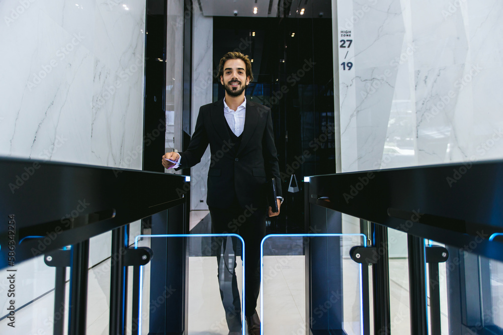 Businessman using card to open automatic gate machine in office ...