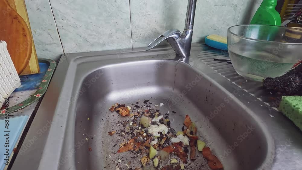 Very dirty greasy sink with leftover food in the apartment. The unkempt ...