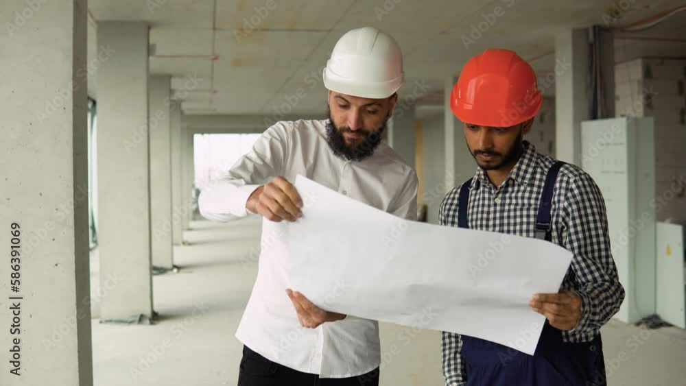 Arab architect is explaining to indian builder the plan of construction ...