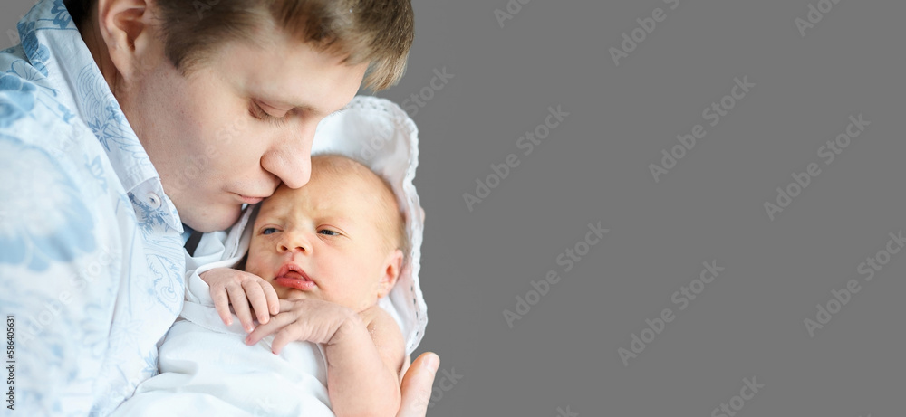 The father gently holds the newborn baby in his arms. Dad loves his ...
