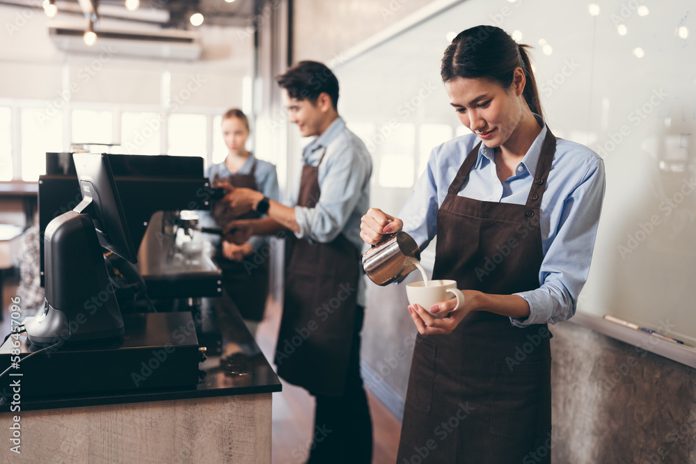 Happy barista Asia woman make coffee of pour milk to coffee cup with ...