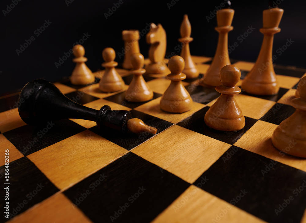 Black King chess moving falling down on chess battlefield in front of ...