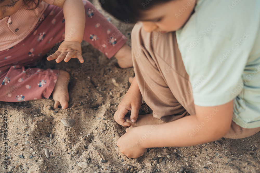 Little kids playing in a sandbox with sand, digging with hands. two ...