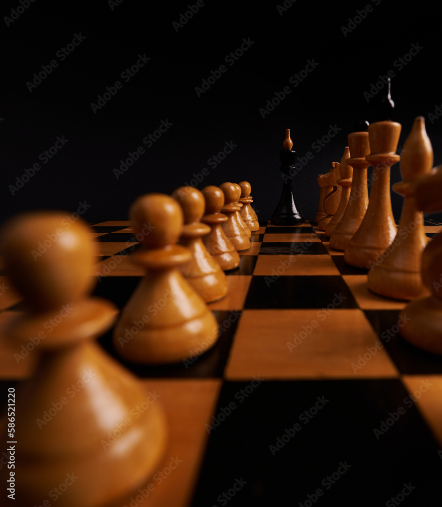 Selective focus on black King chess piece between white pieces on chess ...