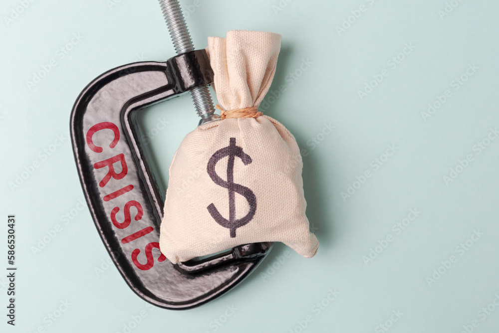 Foto de Money bag with dollar symbol in c-clamp with word Crisis ... Foto de Money bag with dollar symbol in c-clamp with word Crisis ...