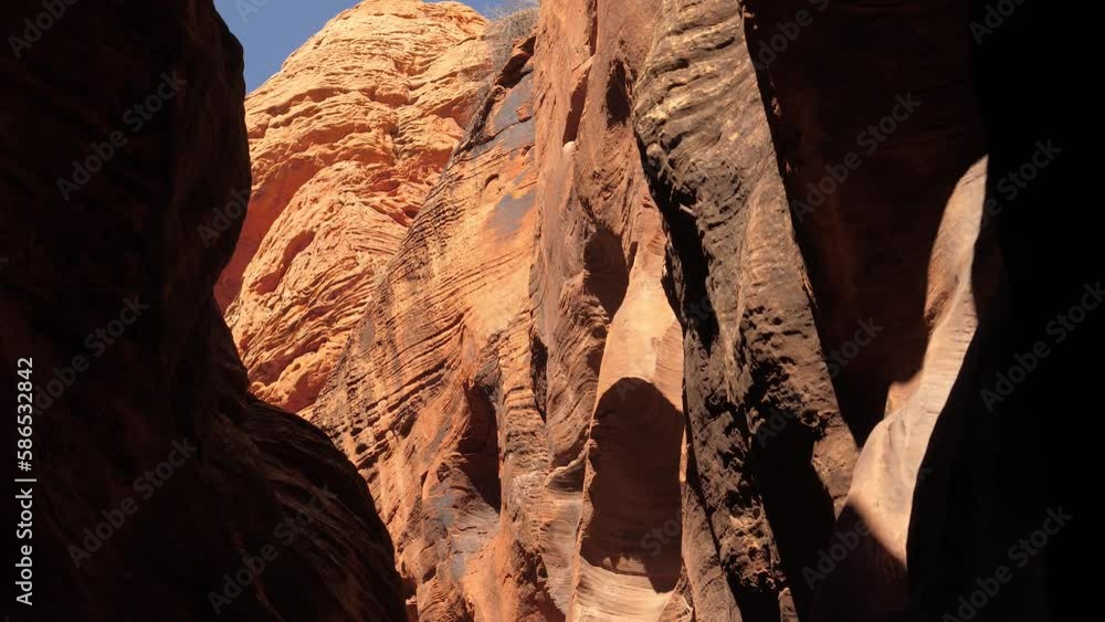 Moving forward in narrow deep slot canyon with smooth red sandstone ...
