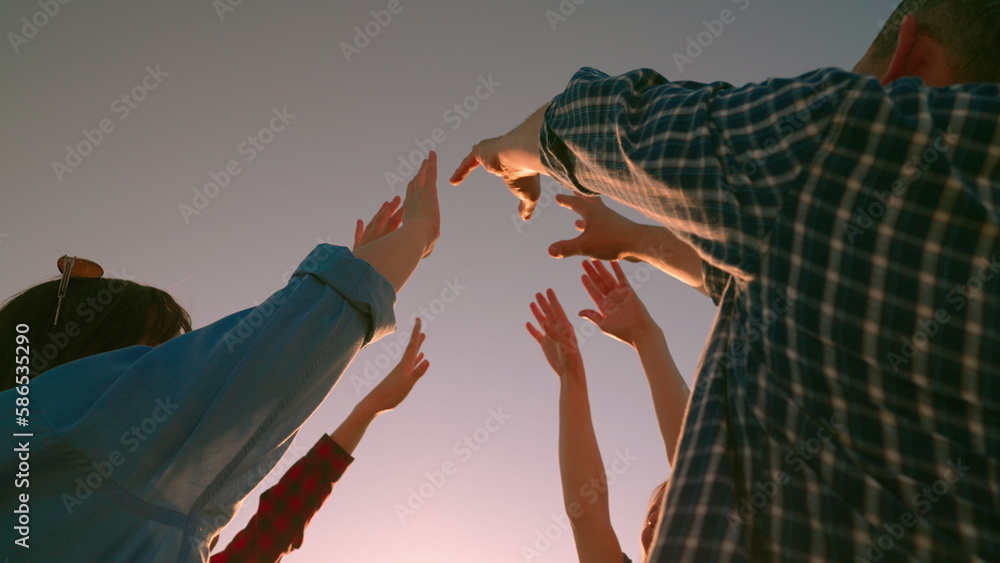 Many people raised their hands to sky, concept of unity and teamwork ...