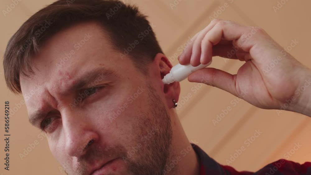 Young caucasian man with a painful grimace on his face dripping liquid ...