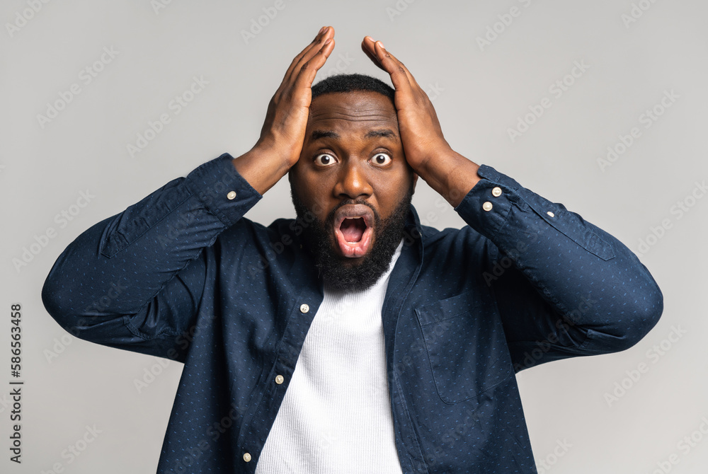 Shocked and terrified African-American guy looks at camera and ...