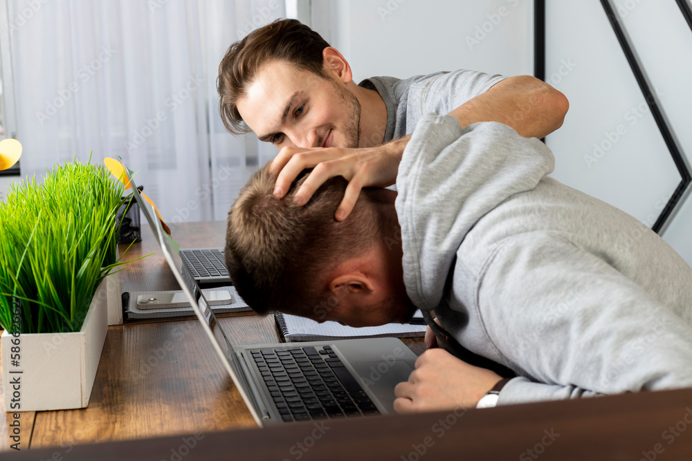A two-person team in the office. An office worker or IT employee points ...