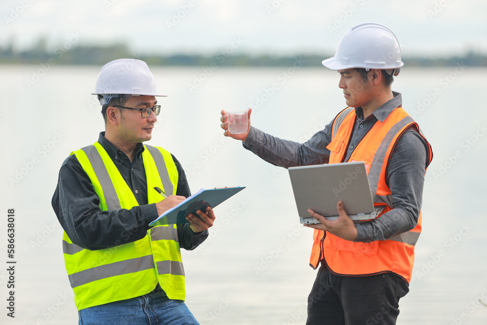 Environmental two engineers work at water source to check for contaminants in water sources and ...