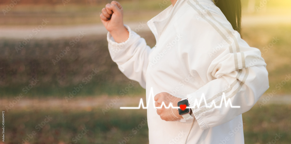Fitness woman with heart rate monitor running on park with running ...