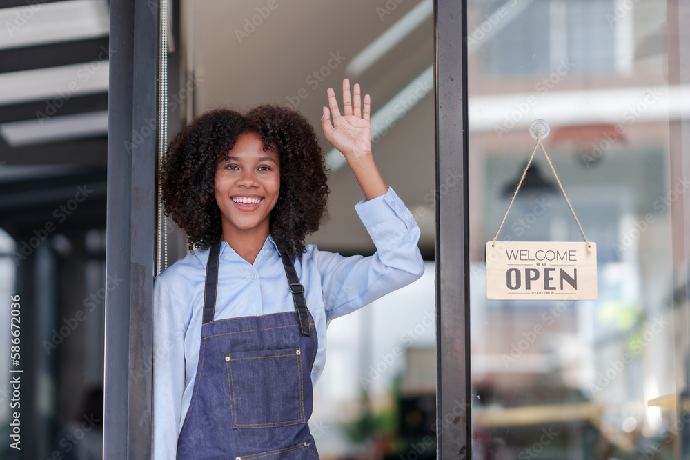 Female store owner or staff, food, cafe or bar, showing the OPEN sign ...