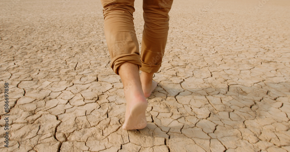Close up shot of feet of adult man walking barefoot on bottom of dried ...