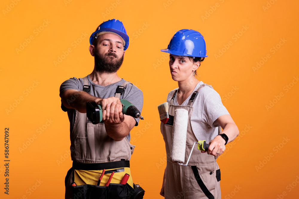 Builders posing with construction or renovation tools on camera ...