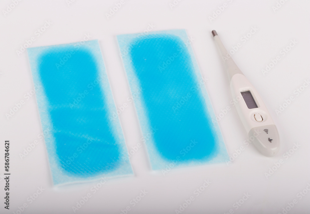 2 of cool fever pad and medical digital thermometer on white background ...