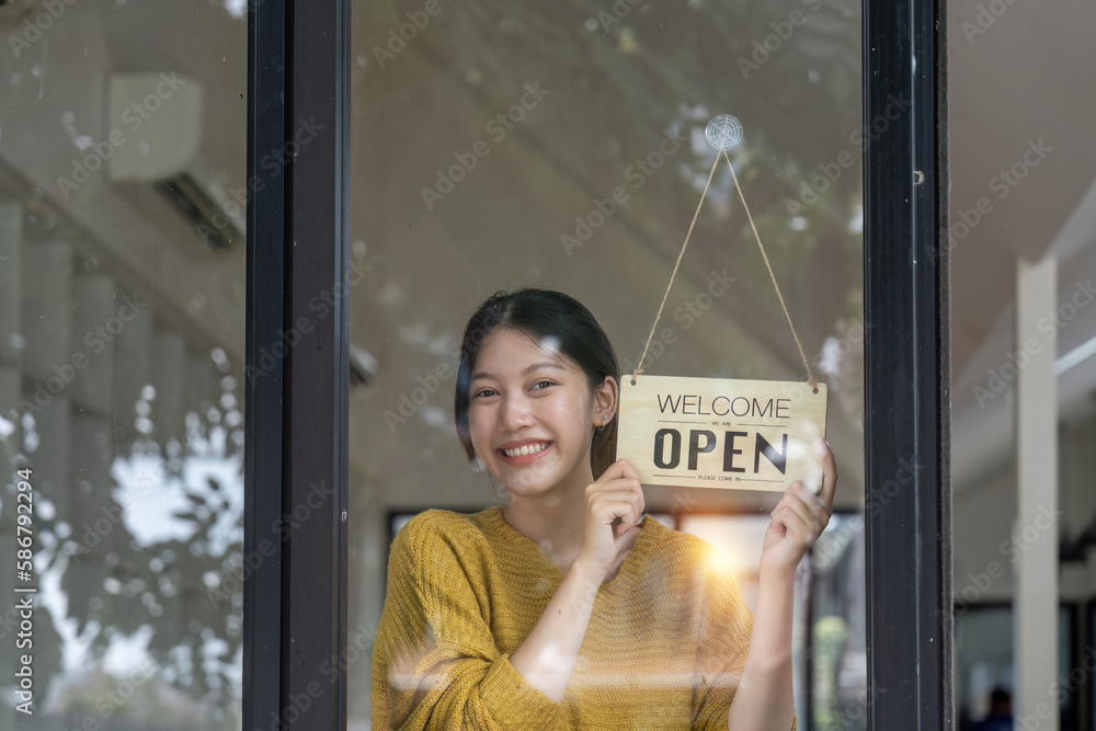 Young woman is a waitress in an apron, the owner of the cafe stands at ...