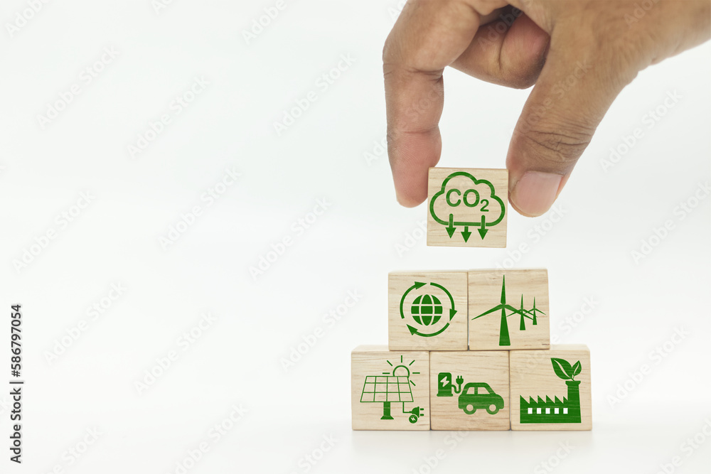 Businessman stacking CO2 reducing ,recycle ,windmill,solar cell,electric car,green factory icons ...