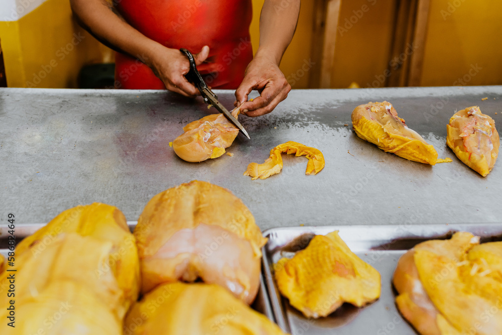 latin man hands of Poultry vendor with raw chickens being sliced by the ...
