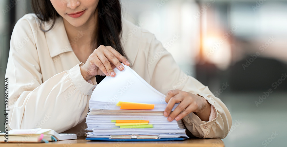 Businesswoman hands working in Stacks of paper files for searching and ...