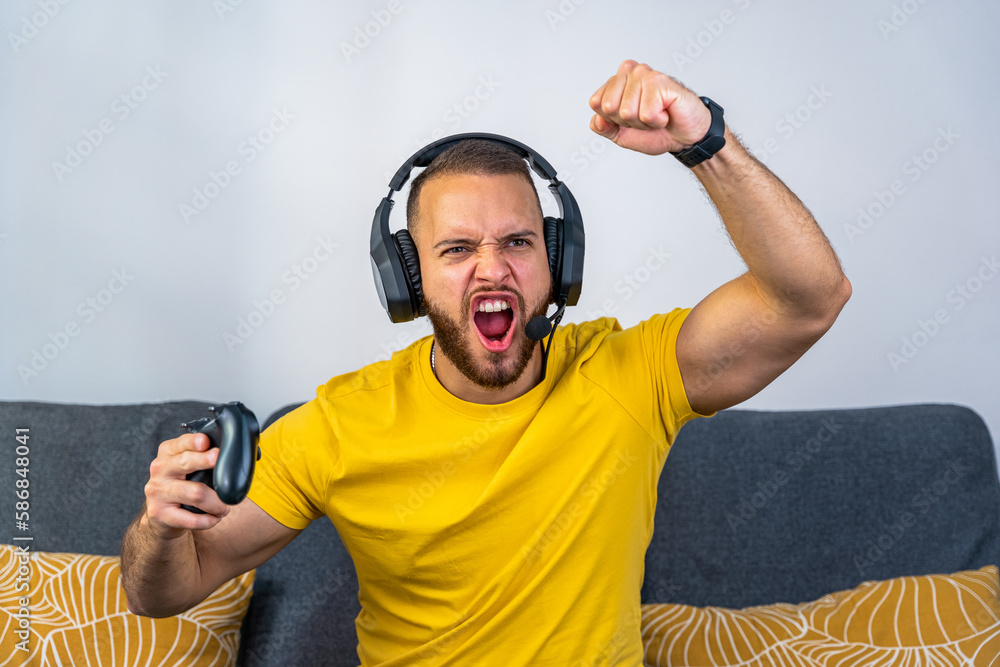 chaval eufórico celebrando victoria gaming con mando de vídeo consola ...