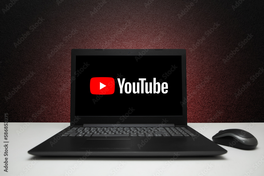 YouTube logo on screen laptop computer with mouse on black textured ...