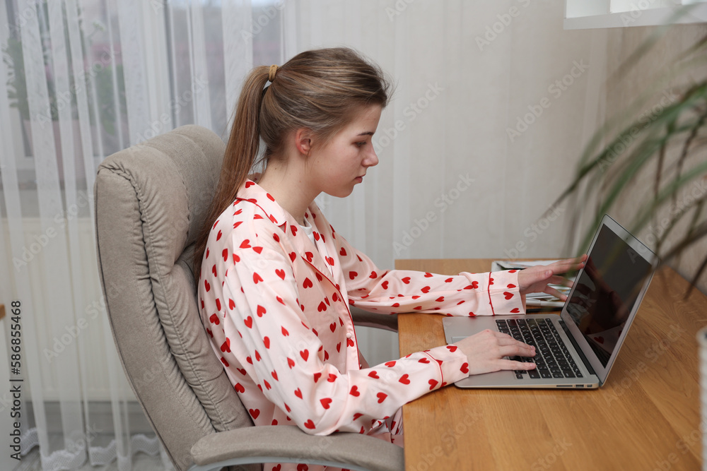 girl in heart print pajamas. a woman in pajamas sits at a table and ...