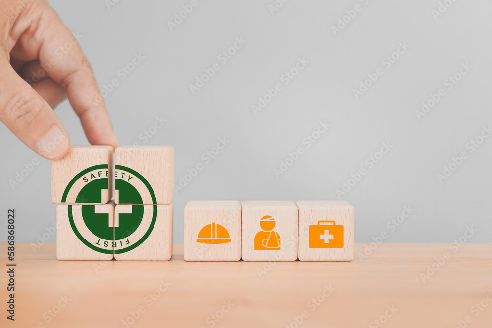 hand arranged wooden cube blocks with safety at workplace icon for ...