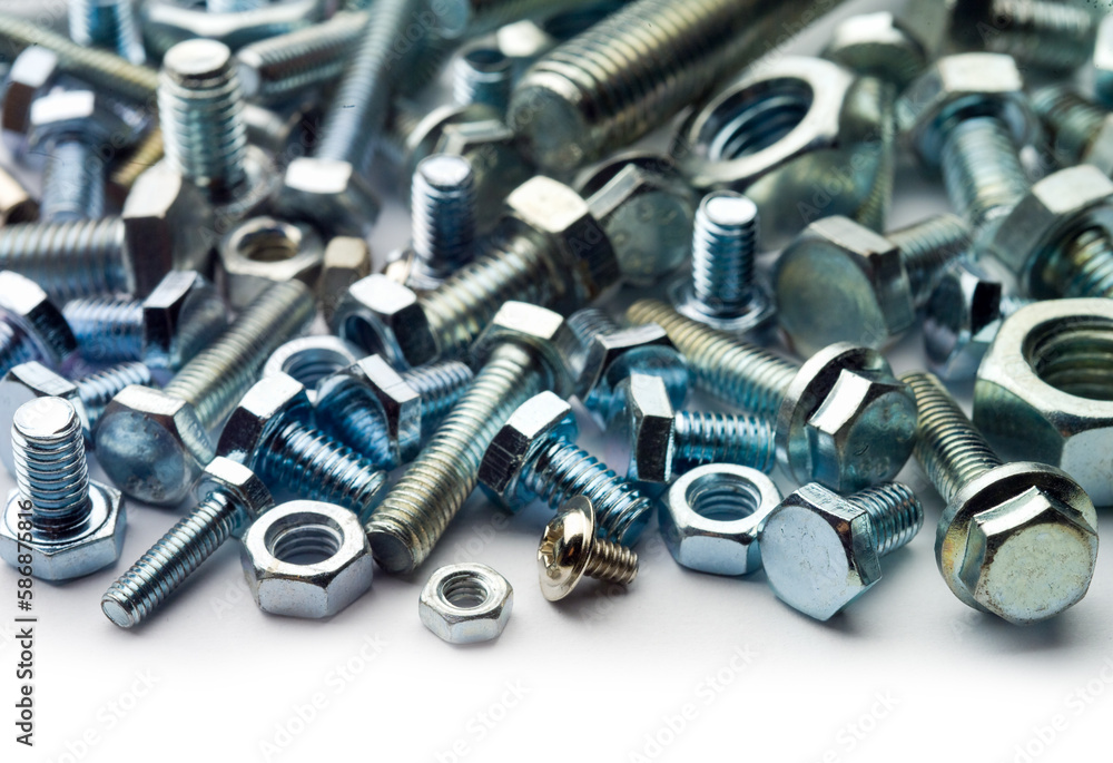 nuts and bolts of different metals forming a texture on a neutral white ...