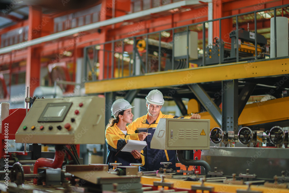 two young engineer assistant in helmet inspection check heavy machine ...