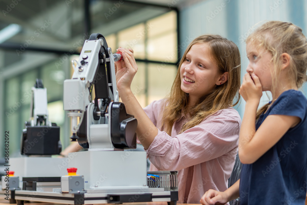 Kid female teen child enjoy Machine Learning Robot arm is Moving Under ...