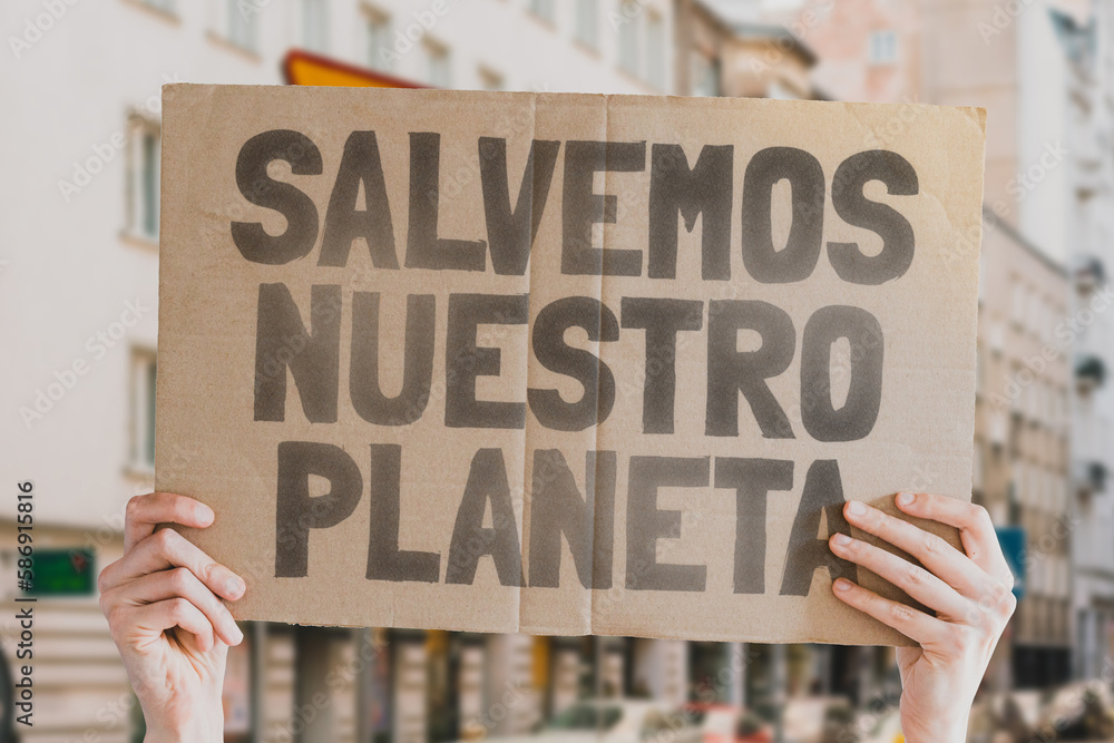 A person holding a brown save our planet cardboard poster. Carbon ...