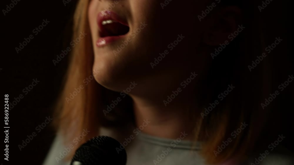 Close-up confident girl singing out loud as live camera moves down to ...