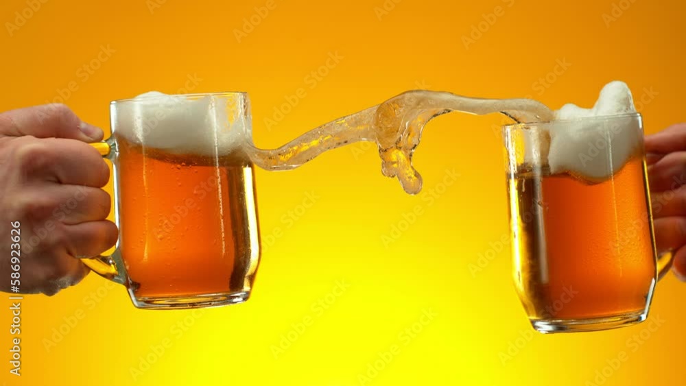 Super slow motion of hitting beer mugs together, cheers concept. Filmed ...