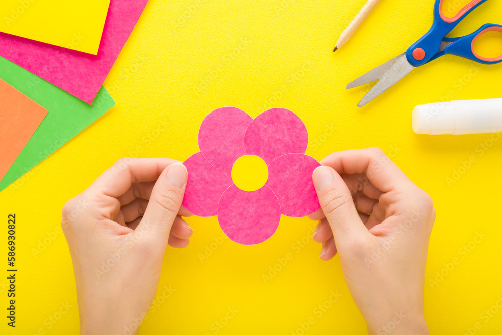 Young adult woman hands holding pink flower head shape from paper on ...