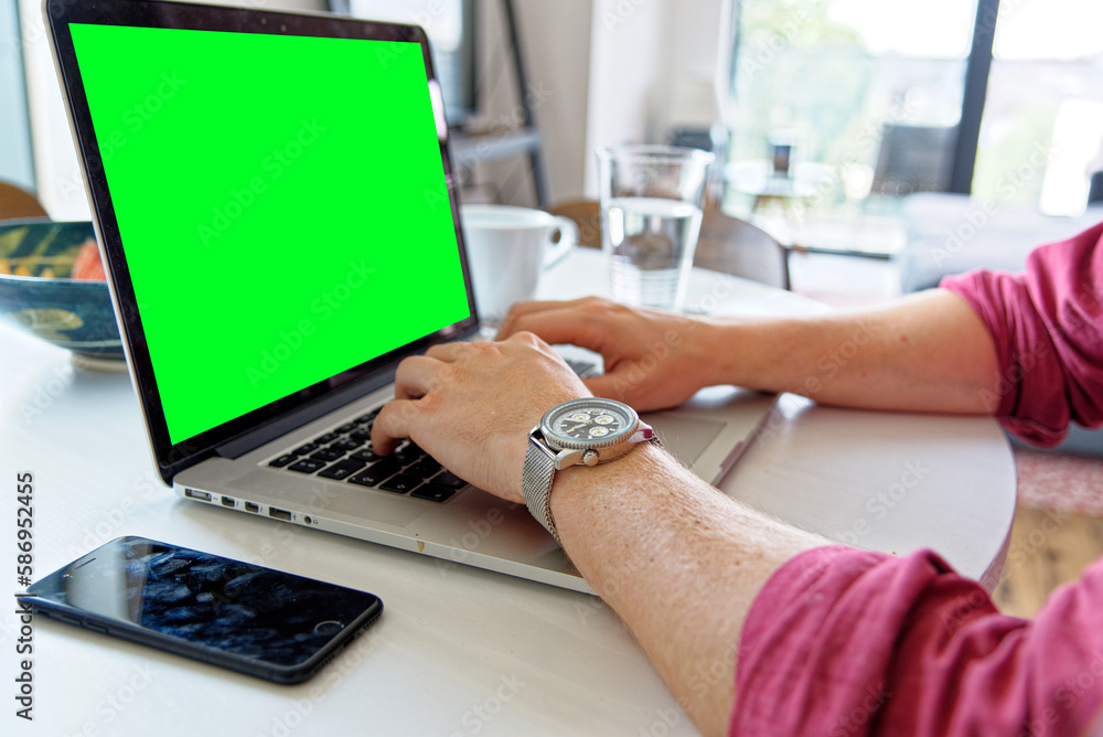 Young professional man using a laptop with a green screen Stock Photo ...