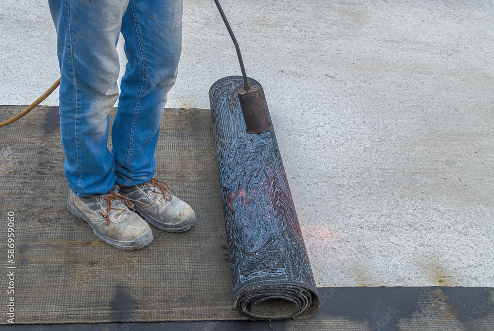 workers insulating rooftop with bitumen membrane. Waterproofing details ...