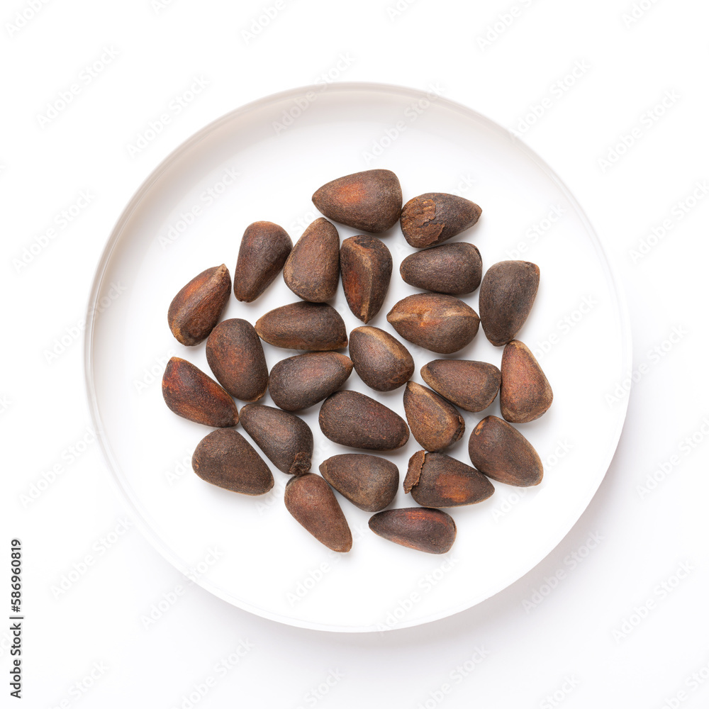 Obraz w ramie Seeds of a stone pine, in a white plastic lid, from above ...