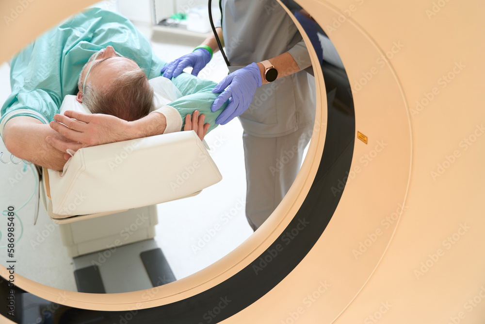 Adult man lying and holding hands up in chamber of MRI machine Stock ...