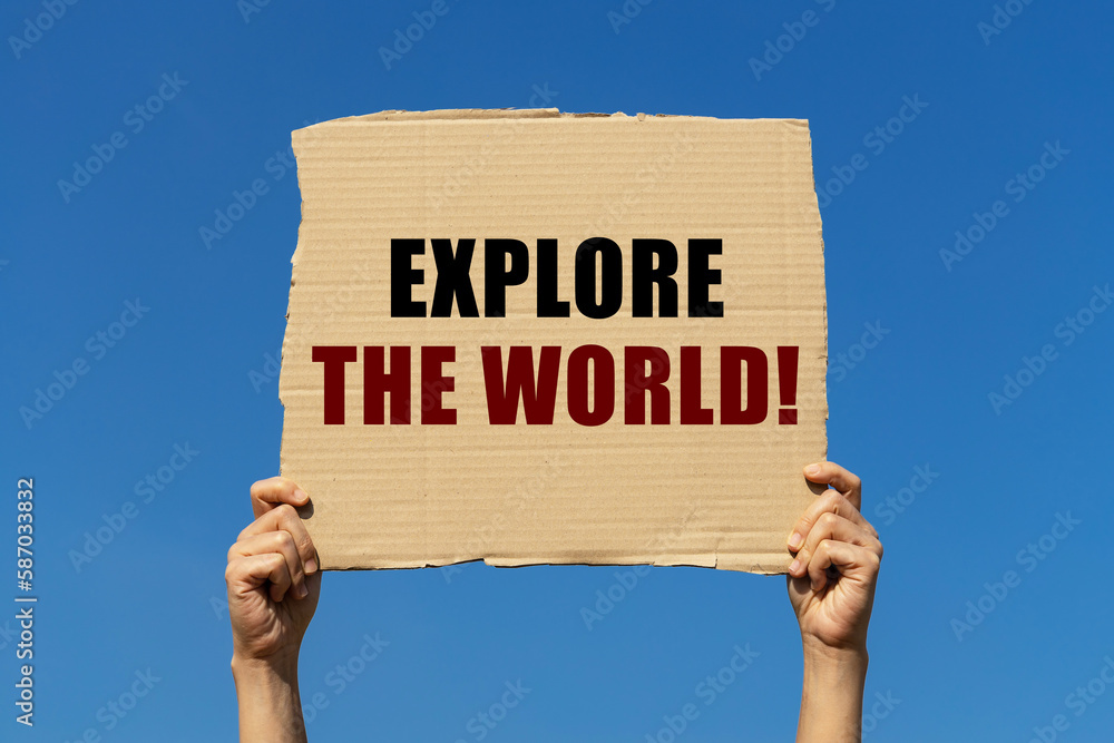 Explore the world text on box paper held by 2 hands with isolated blue ...