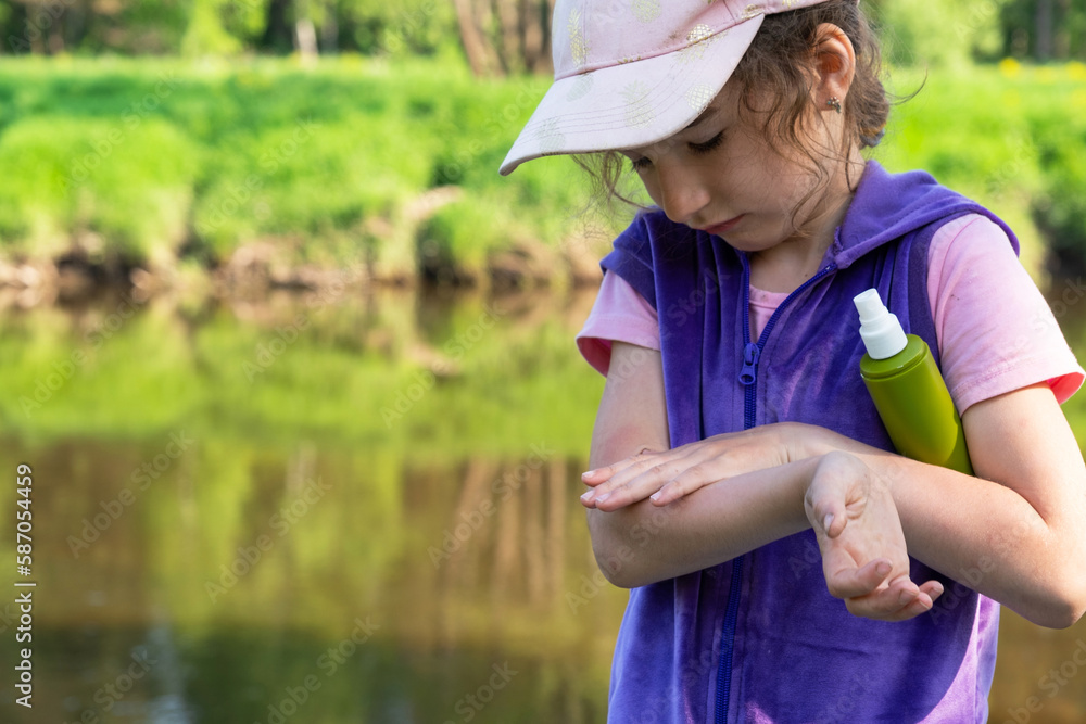 Girl uses a remedy for mosquitoes and biting insects in nature ...