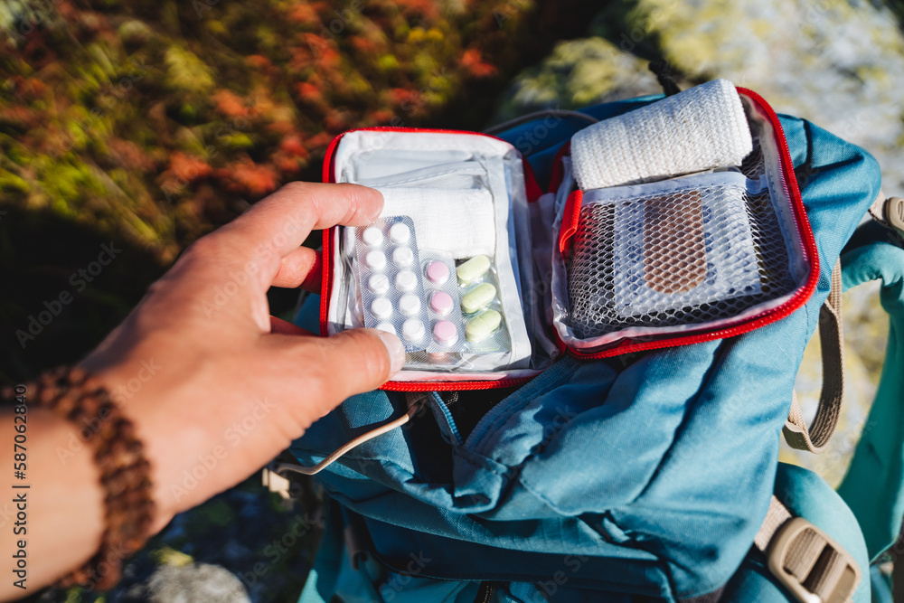 An open first-aid kit with medicines for a hike, a set of pills for ...
