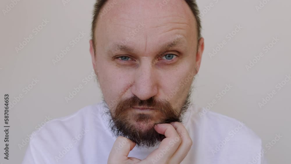 Angry bearded man looking at camera. Close up displeased guy with ...