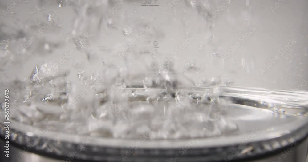 Boiling water with bubbles at the bottom of the electric kettle, slow ...