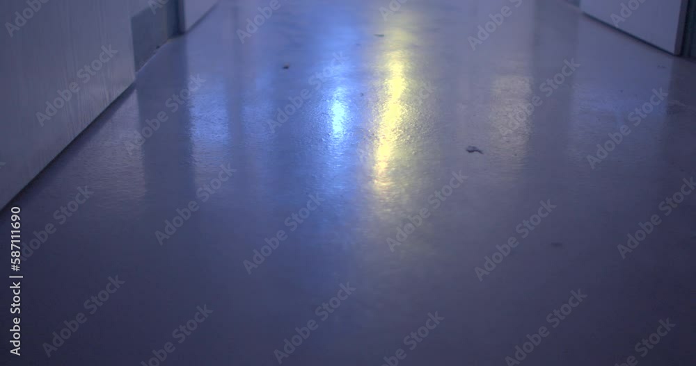 Reflection of flashing light in the floor surface of a dark room. Blue ...