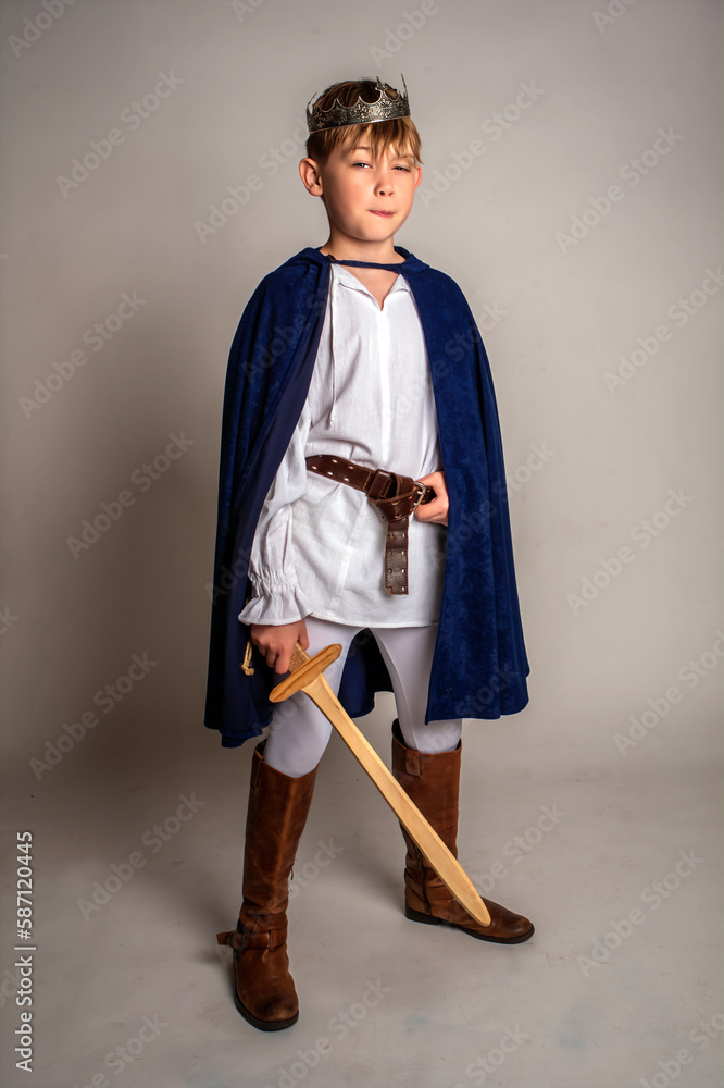 Young preteen model boy dressed as a cosplay prince standing in studio ...