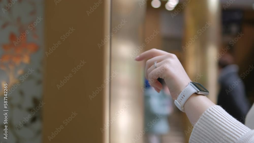 Woman using touchscreen terminal in mall. Detail view outstretched ...